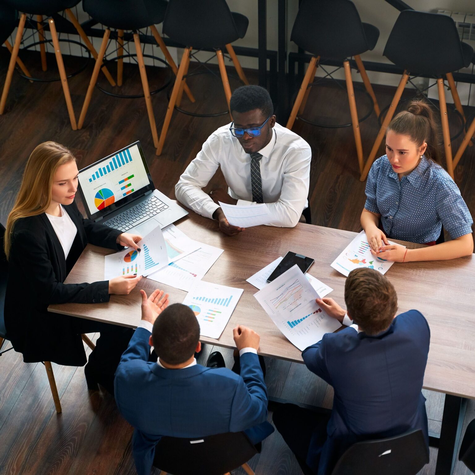 Multiracial team at office negotiation table led by female CEO ...